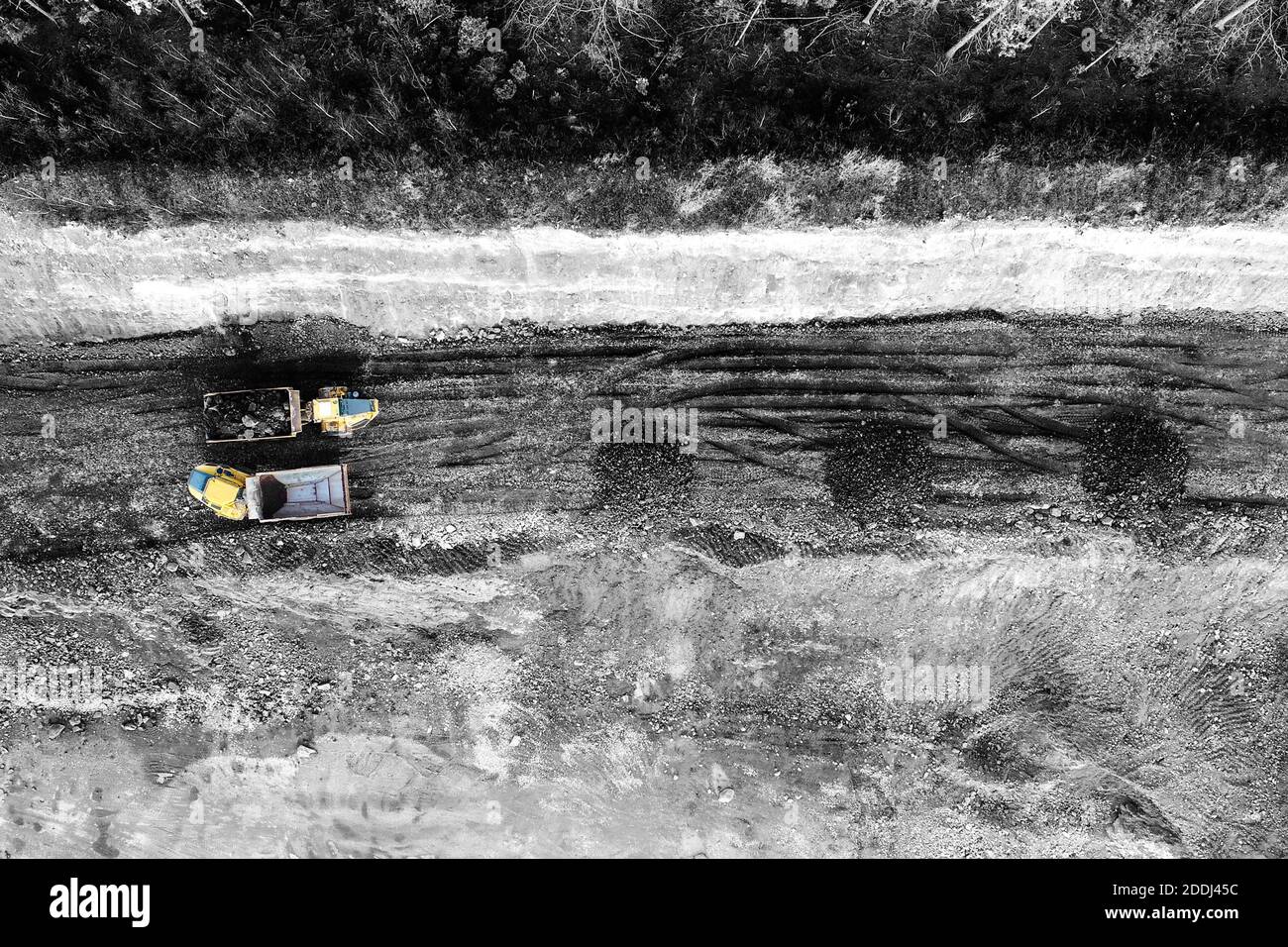 Heavy machines, including yellow trucks, in the working environment in ...