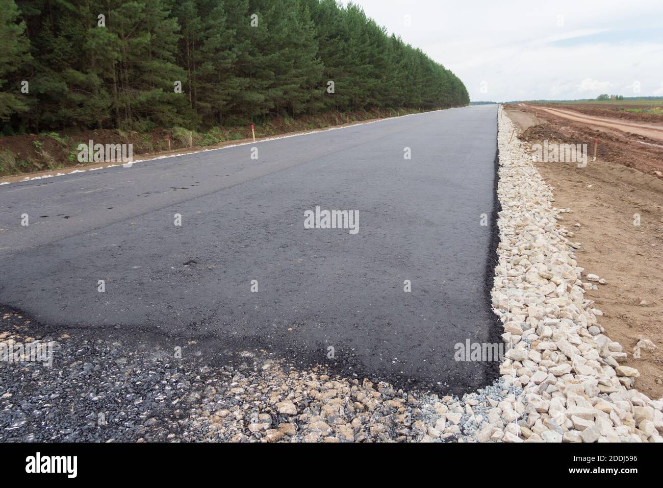 Construction of a new road. Fresh asphalt laying. The beginning of the ...