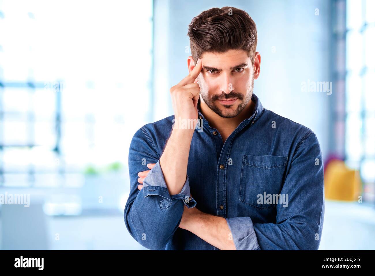 Shot of thinking man wearing cacual clothes while standing indoor. Copy ...