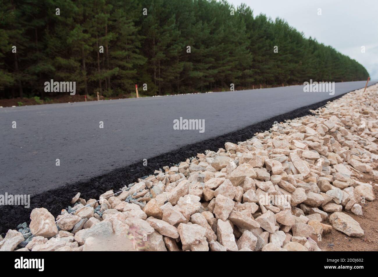 Stones on the edge of the asphalt road The border of the asphalt road ...