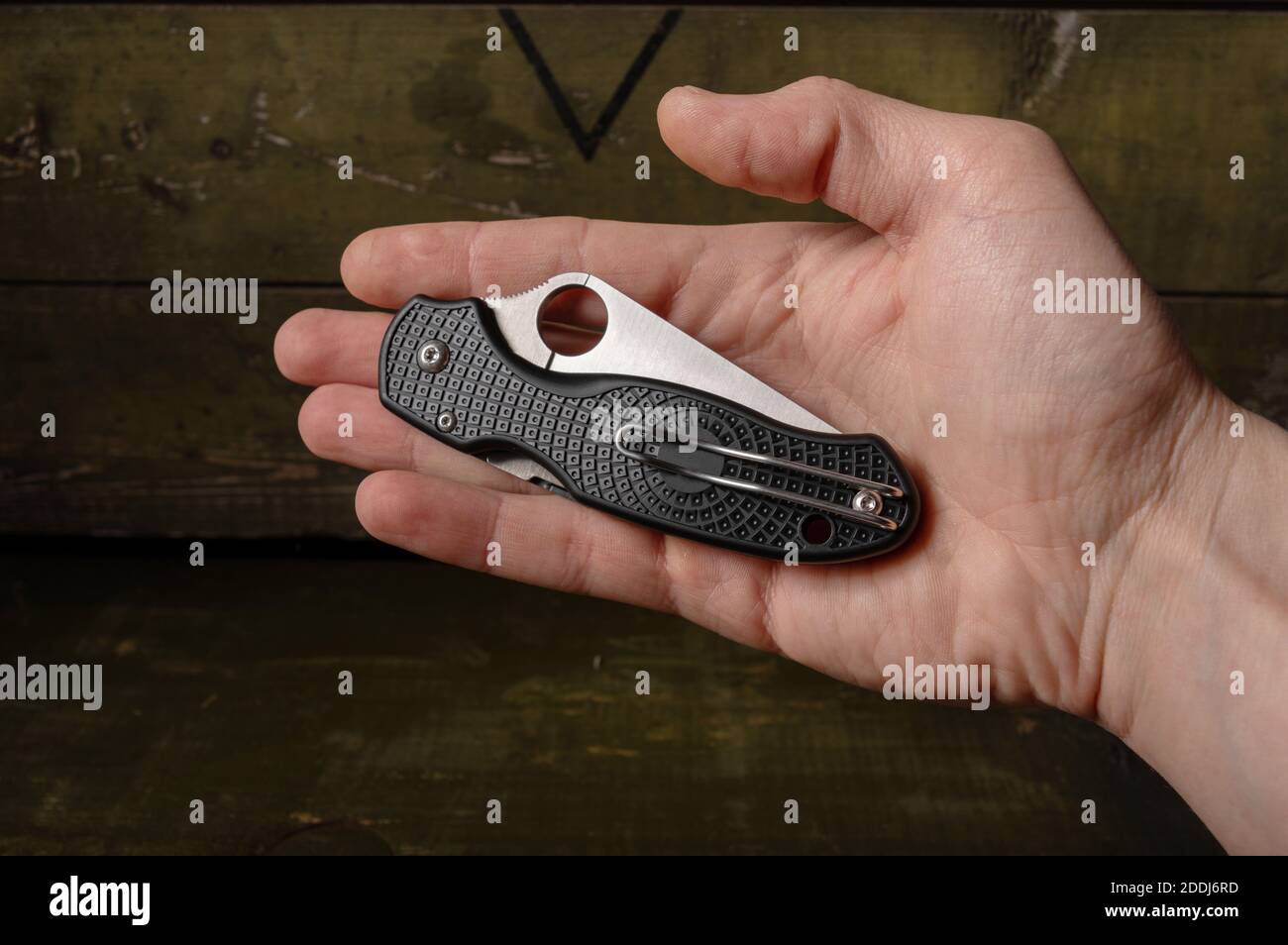 Knife with a clip in a folded position in the palm. Folded knife in ...