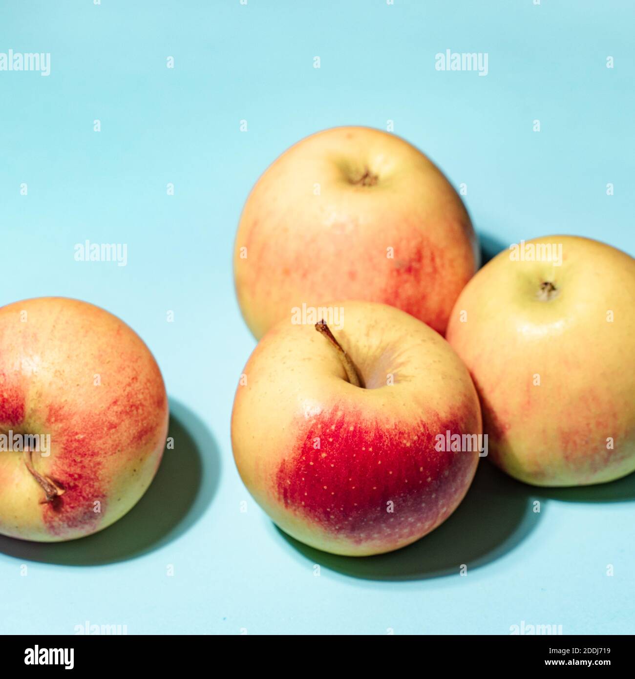 Apples on blue background art image Stock Photo - Alamy