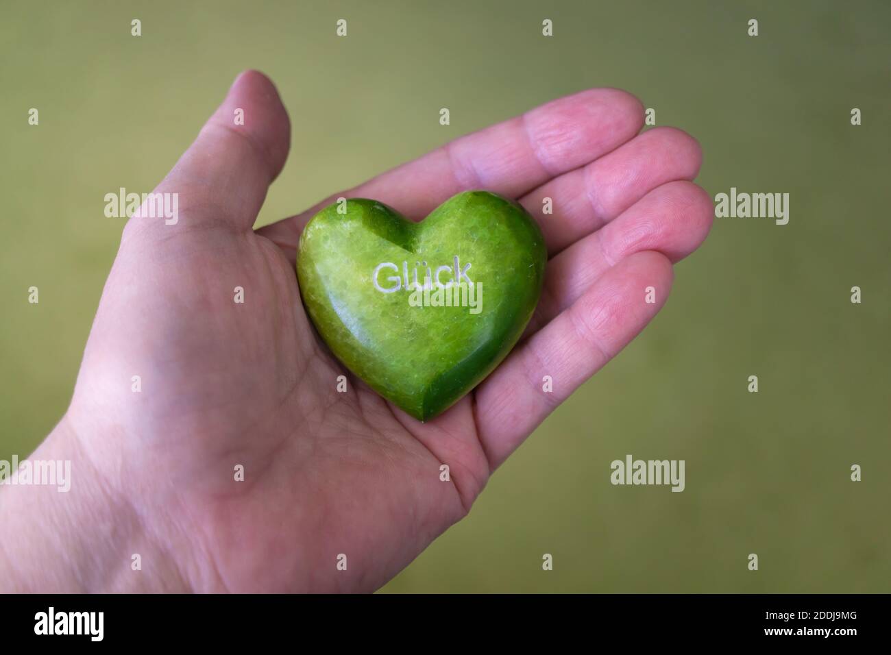A hand holding a lucky green heart Stock Photo - Alamy