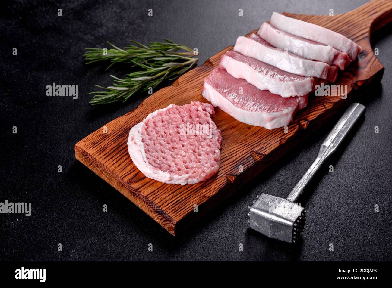 A fresh raw piece of pork escalop cut into several parts. Preparing ...