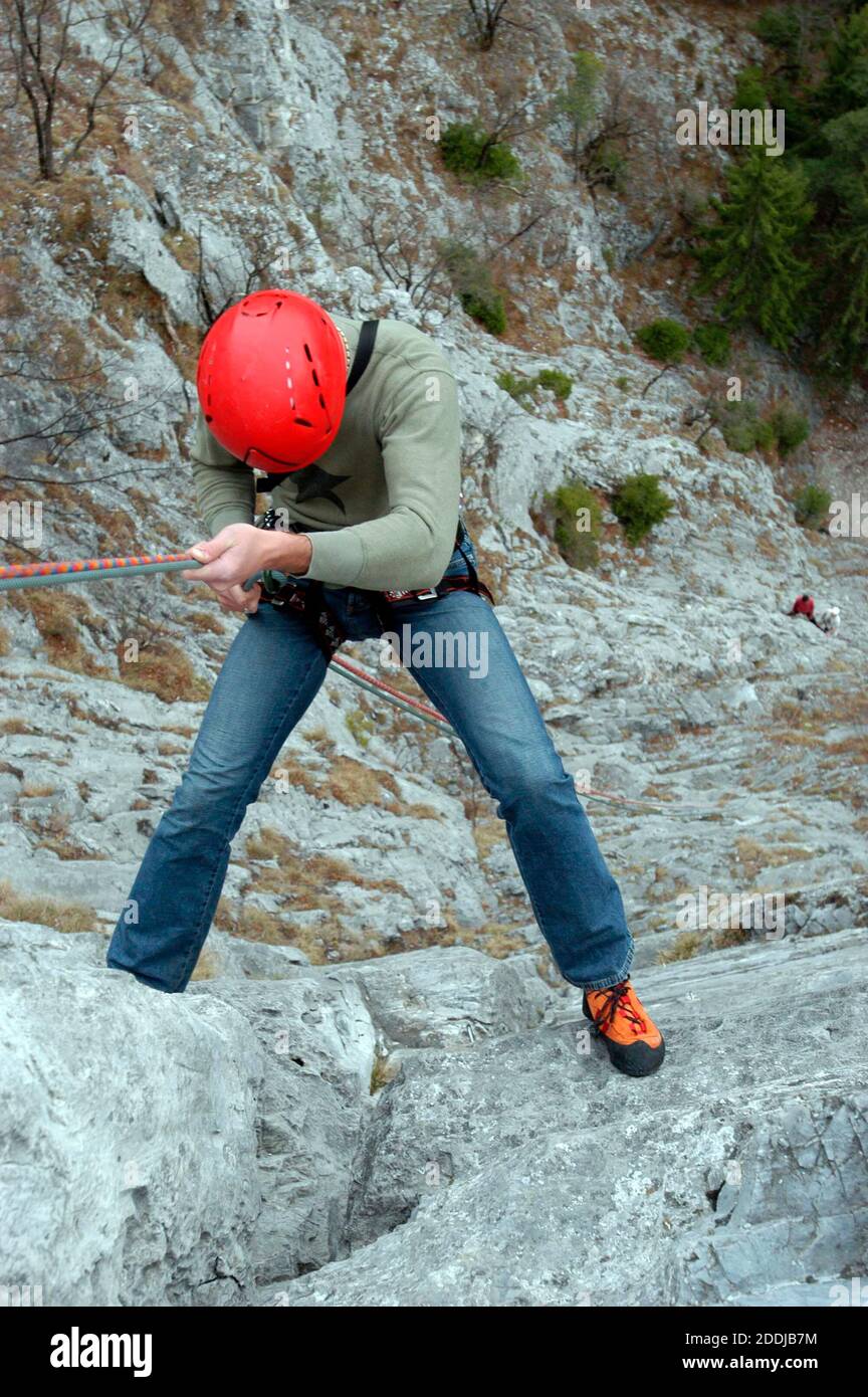 abseiling or rappelling, a controlled descent with a rope in alpine ...