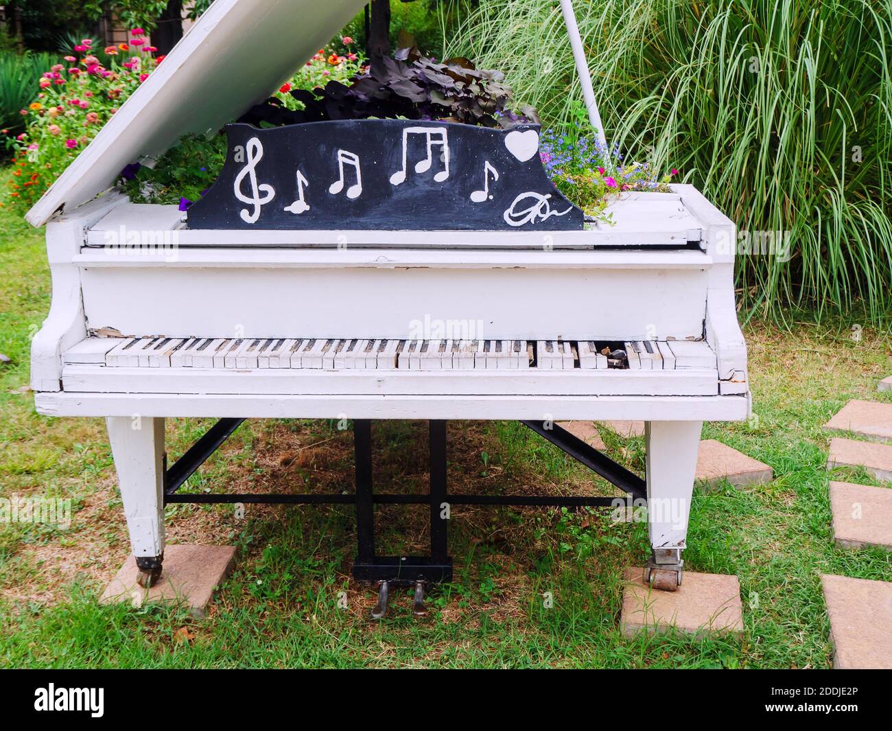 White decorative grand piano with broken keys and notes painted on top ...