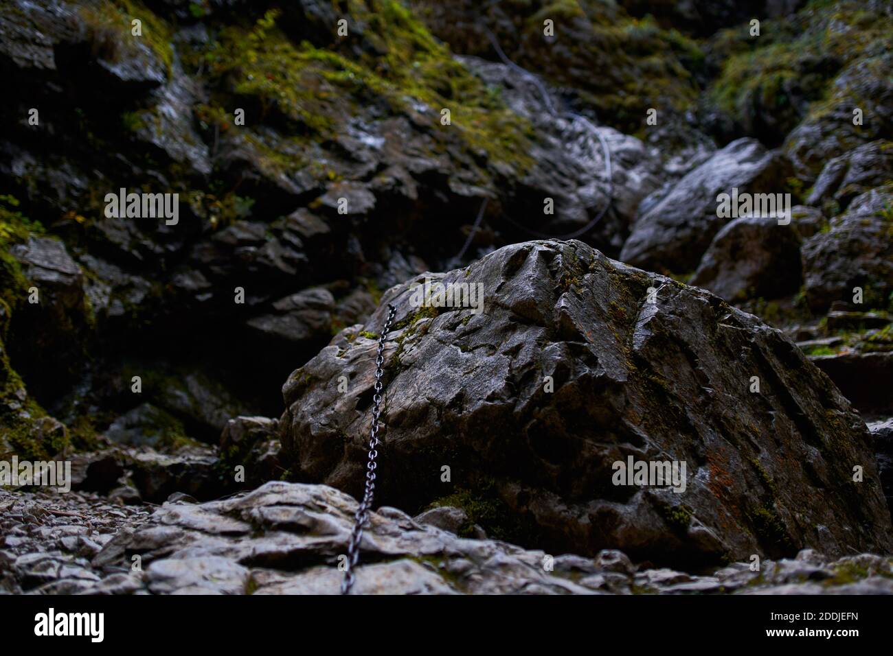 Safety chain hanging on boulders on a dangerous mountain trail Stock ...