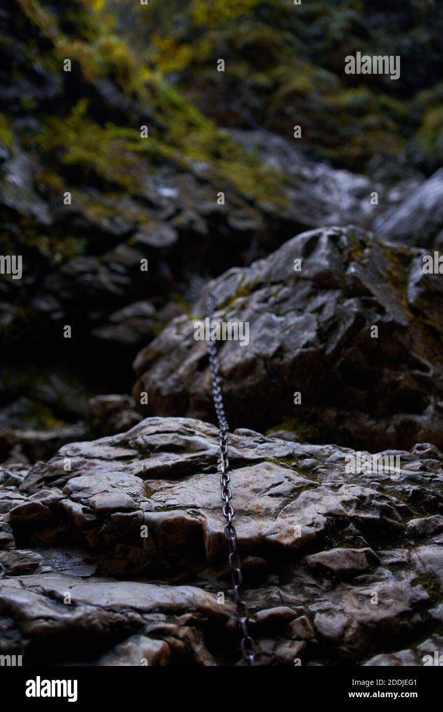 Safety chain hanging on boulders on a dangerous mountain trail Stock ...