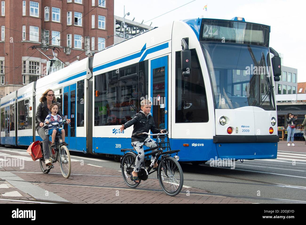 Family cycling past a streetcar in downtown Amsterdam, Netherlands ...