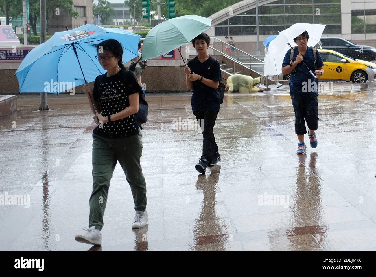 People struggle with heavy rain and strong winds brought by typhoon ...