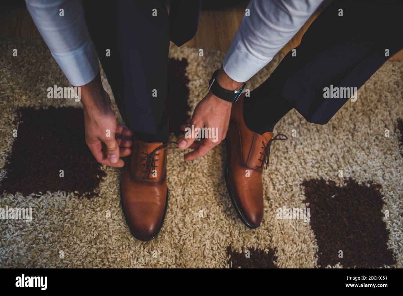 An overhead view of an elegant man tying his brown leather shoes Stock ...