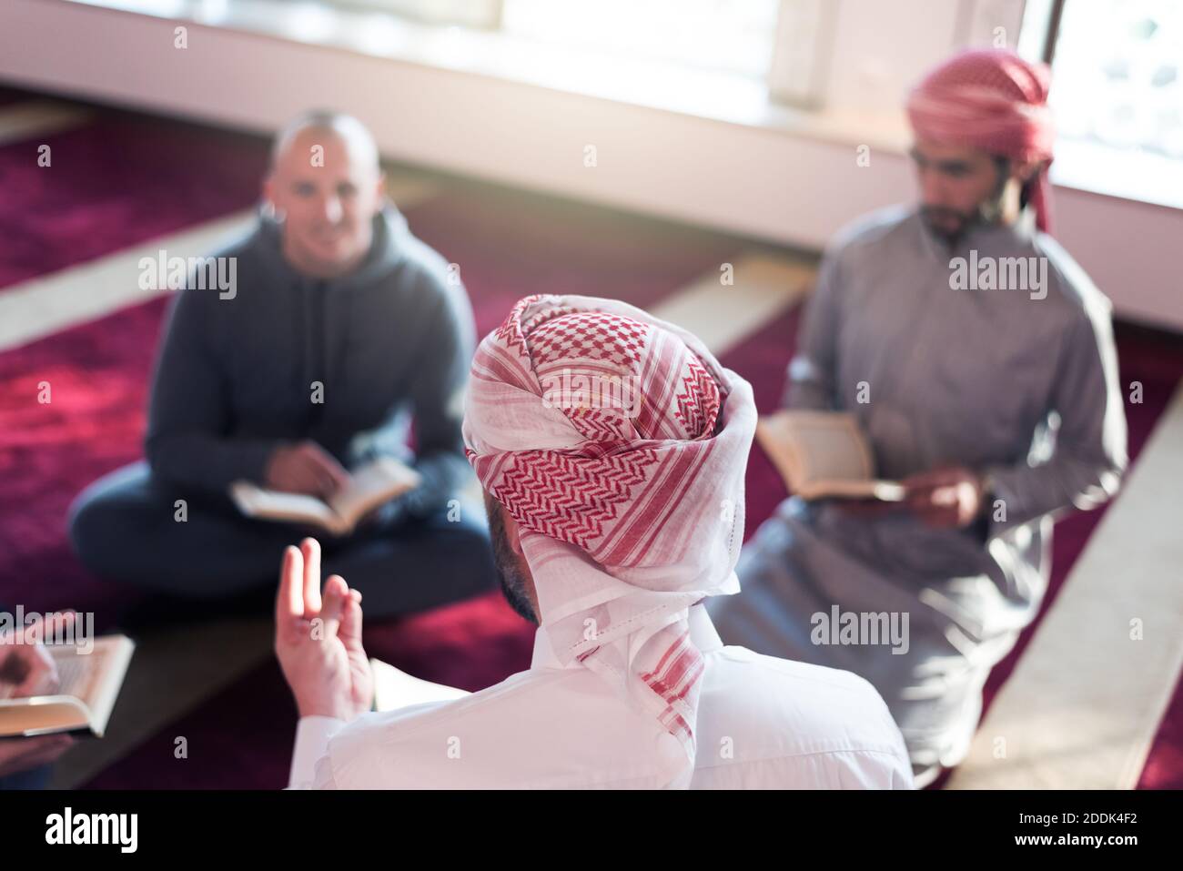Group of muliethnic religious muslim young people praying and reading ...