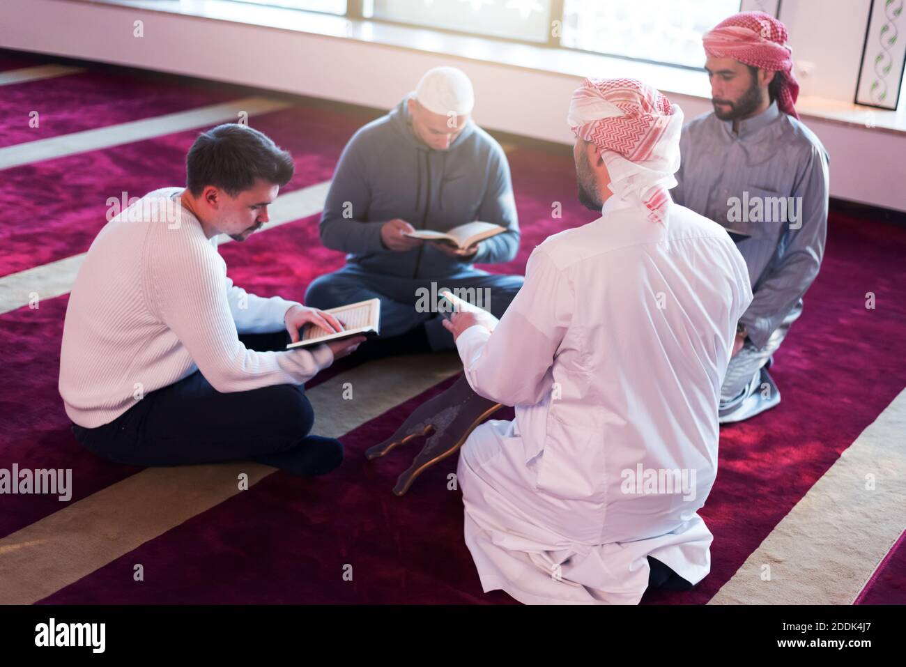Group of muliethnic religious muslim young people praying and reading ...