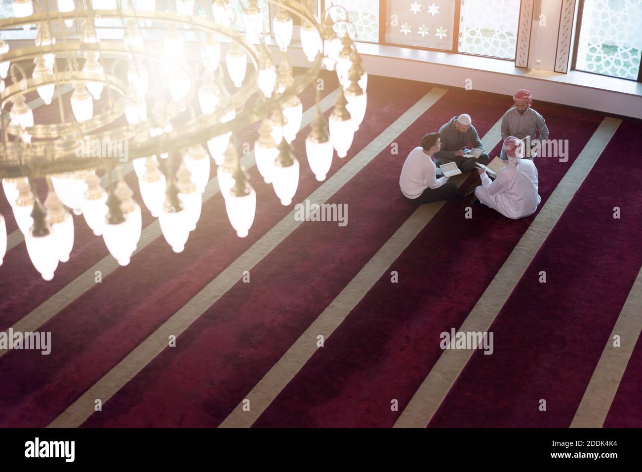 Group of muliethnic religious muslim young people praying and reading ...
