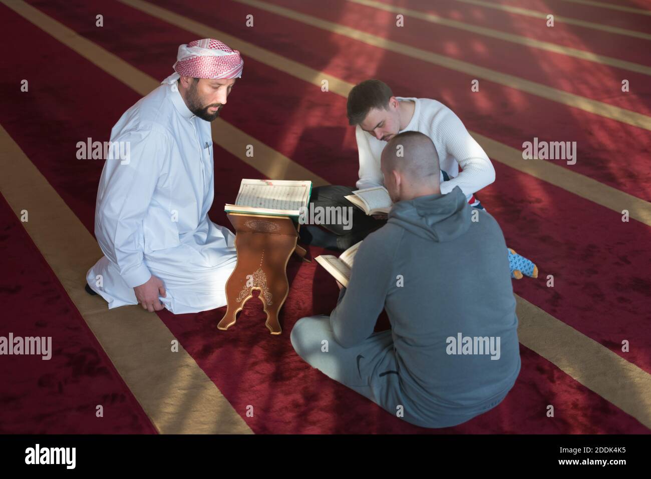 Group of muliethnic religious muslim young people praying and reading ...