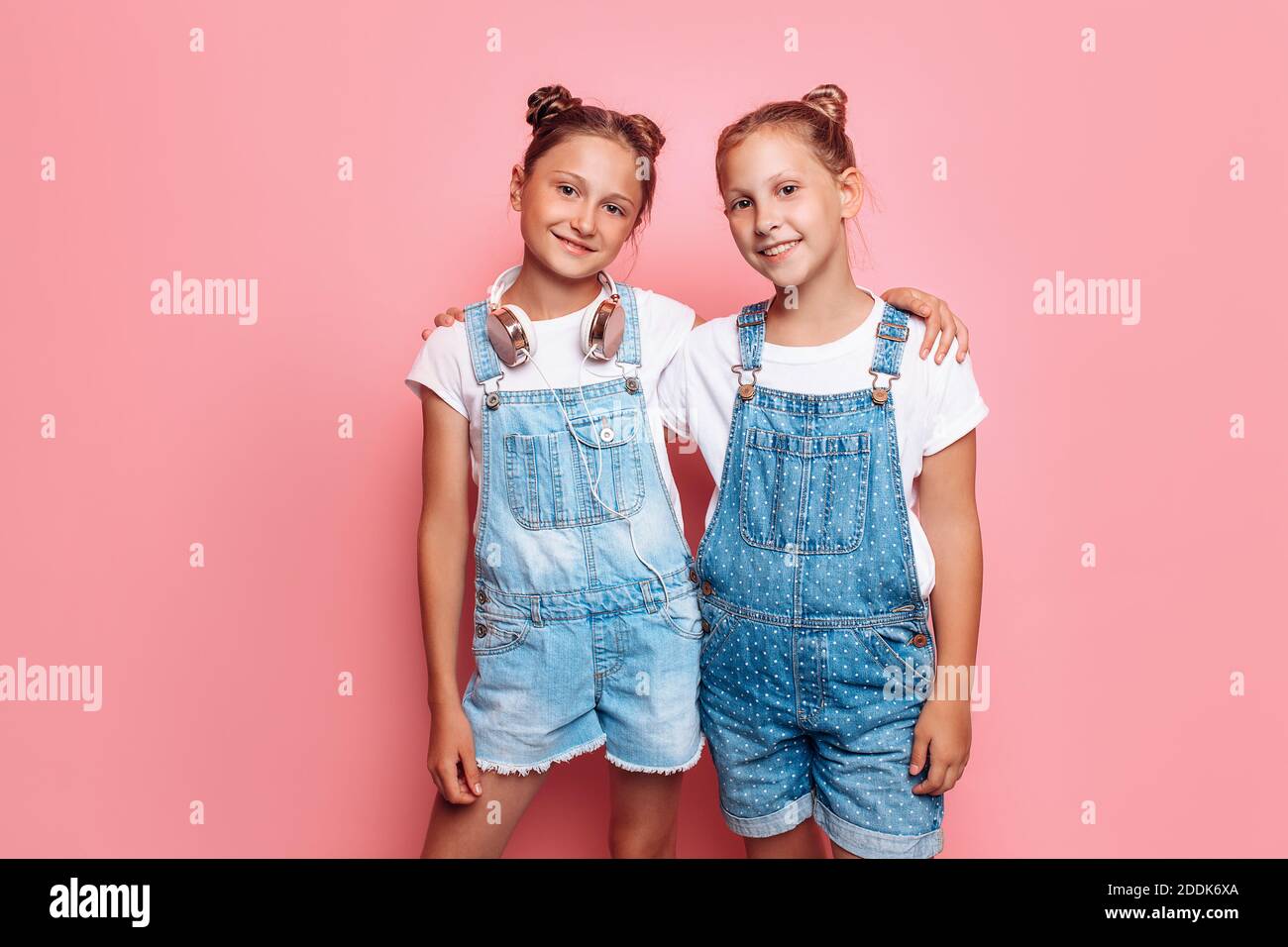 Two stylish teenage girls posing on a pink background Stock Photo - Alamy