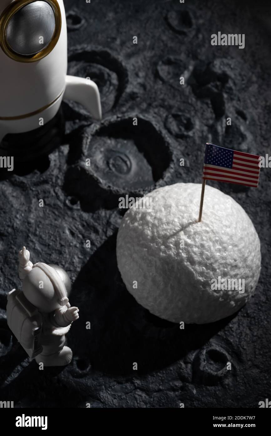 astronaut cheering up and facing the American flag on a planet with ...