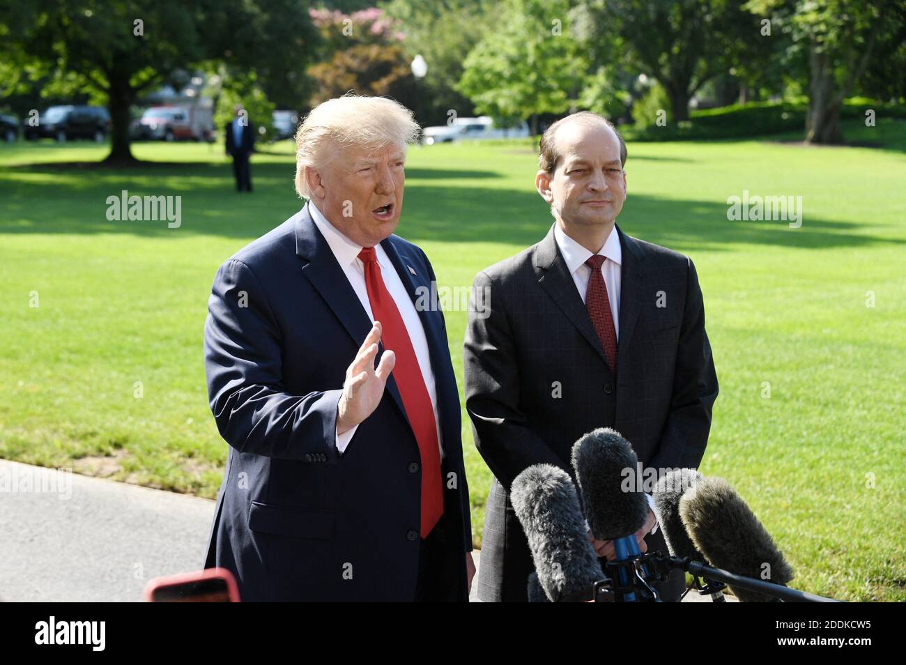 U.S. President Donald Trump stands with Labor Secretary Alex Acosta ...