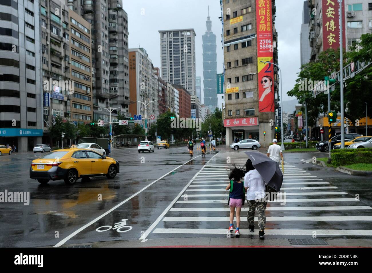 People struggle with heavy winds and rain while crossing the street as ...