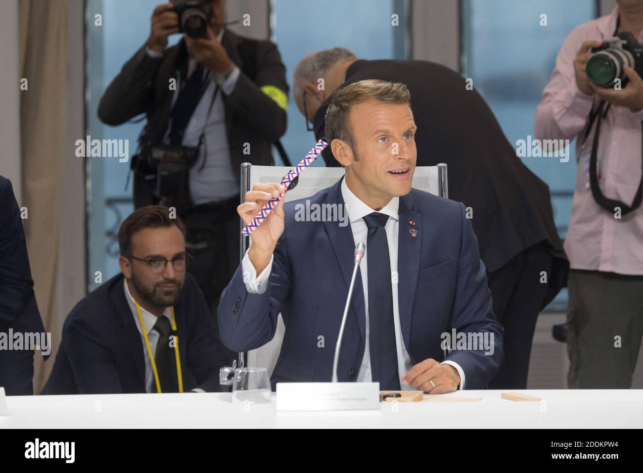 French President Emmanuel Macron shows a watch made of recycled plastic ...