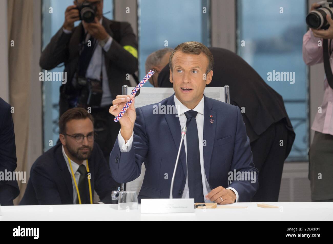 French President Emmanuel Macron shows a watch made of recycled plastic ...