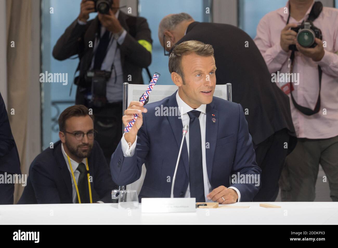 French President Emmanuel Macron shows a watch made of recycled plastic ...
