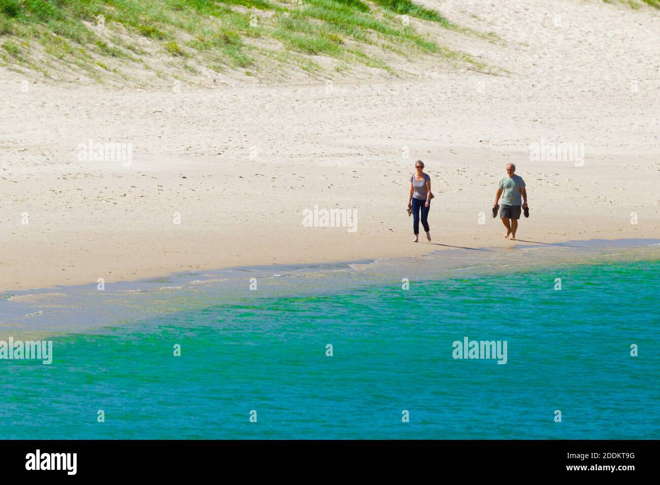 A couple walking on the beach at Bumbora Point at Yarra Bay on Botany ...