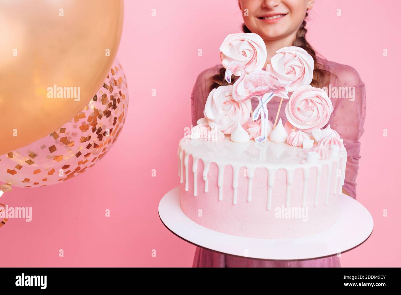 Girl holds cake in hands on a pink background Stock Photo - Alamy