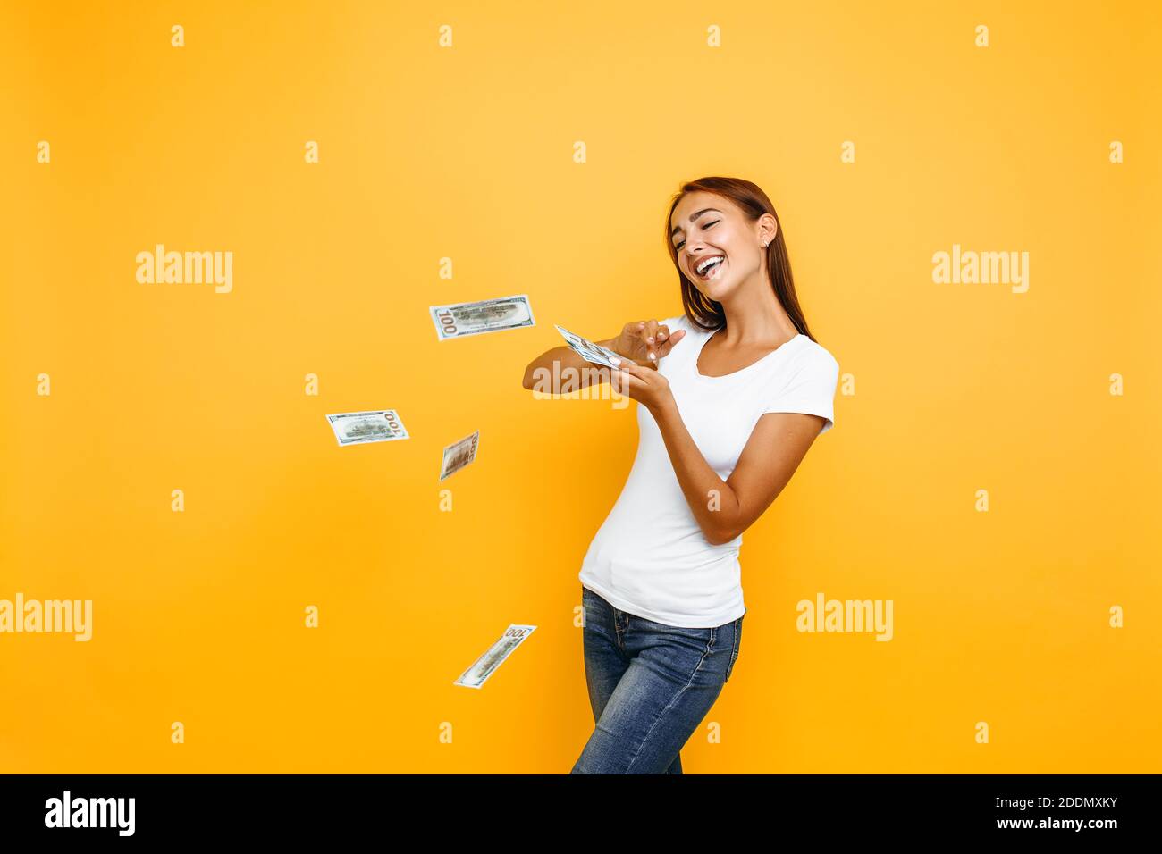 Crazy rich woman throws away money banknotes, lots of dollars isolated ...