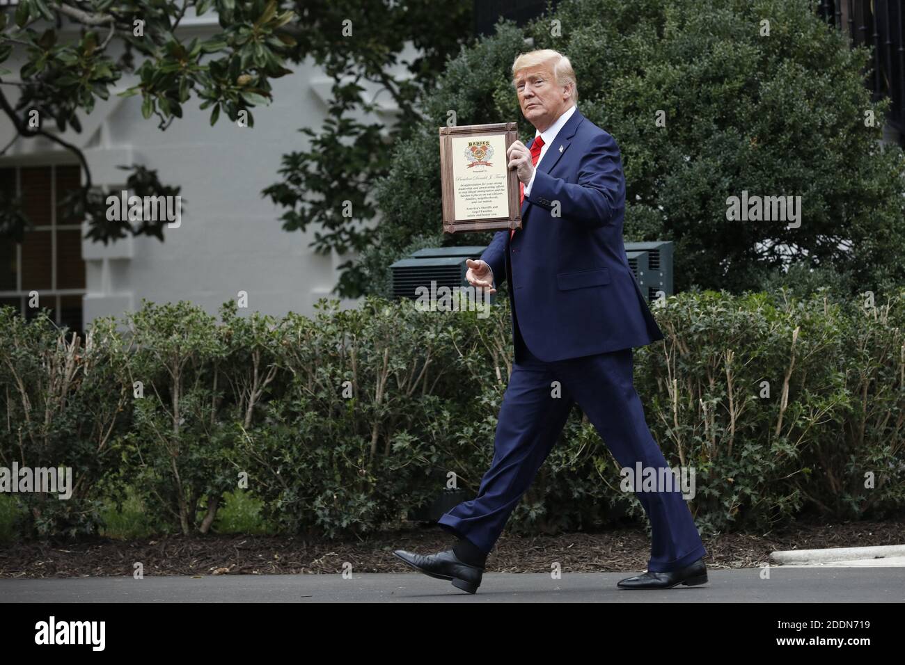 U.S. President Donald Trump carries a appreciation plaque presented him ...