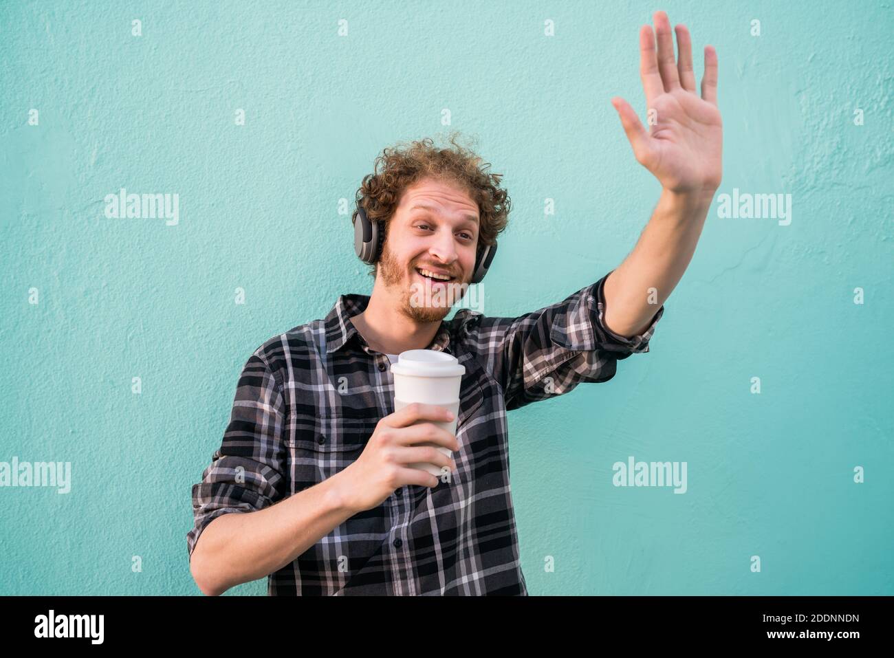 Man waving his hand and smile saying hello to someone Stock Photo - Alamy