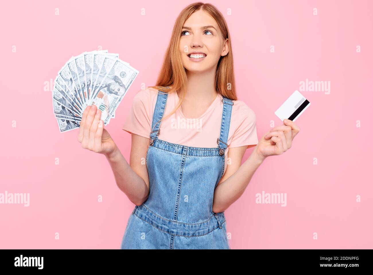 Portrait of a smiling successful young girl showing a lot of money in ...