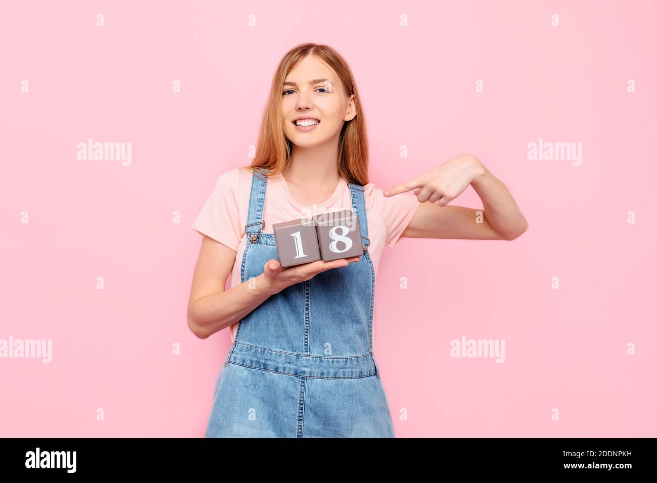 A cheerful cute young woman is celebrating her birthday and holding ...