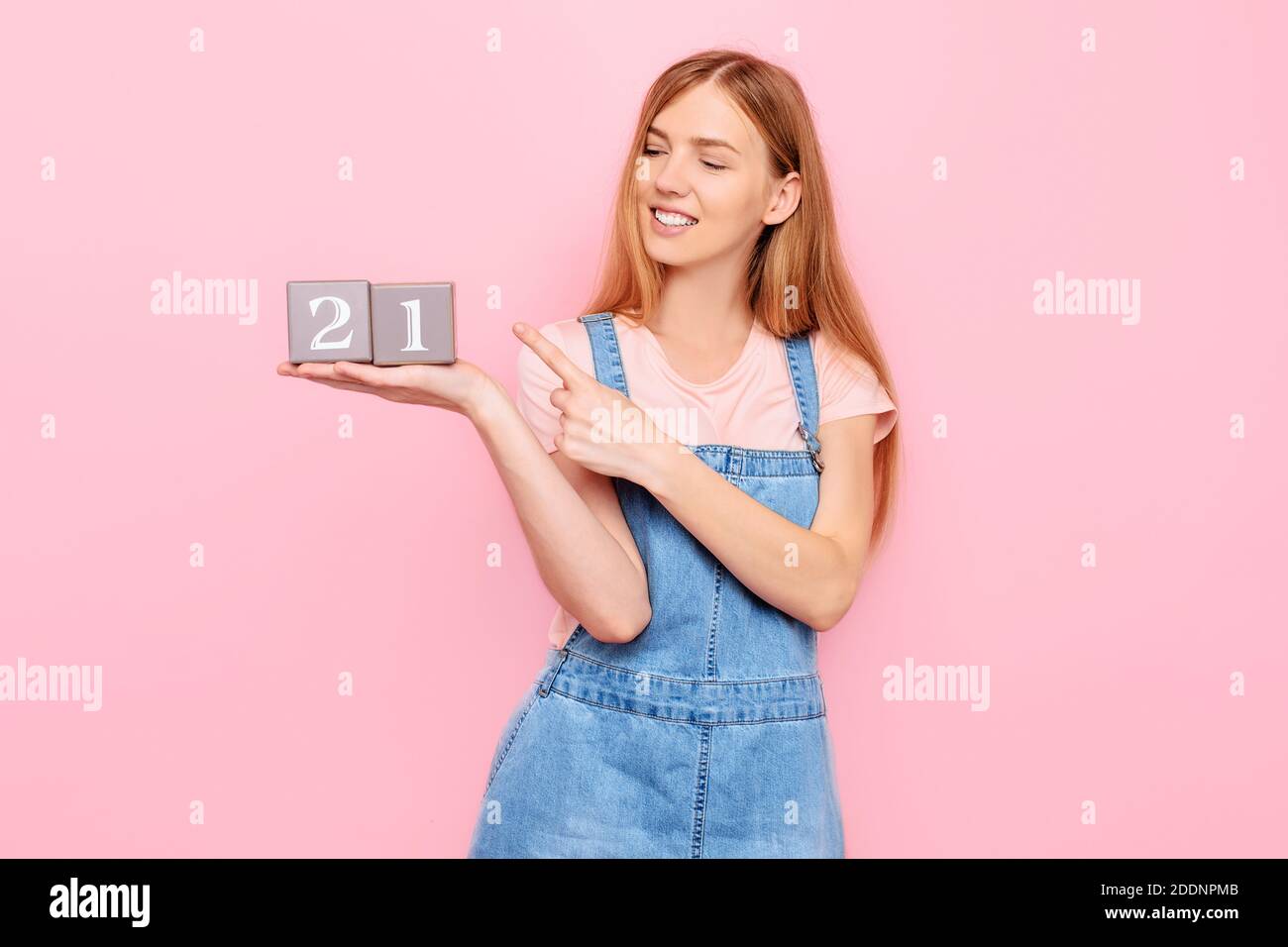 A fun cute young girl is celebrating her birthday and holding cubes ...