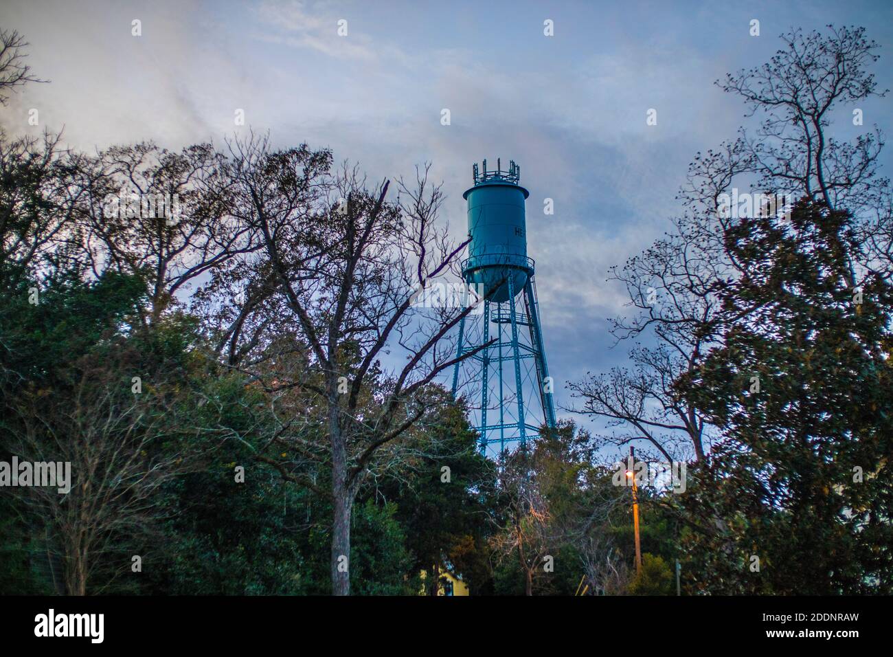 An old water tower and trees with cloudy skies in the south Stock Photo ...