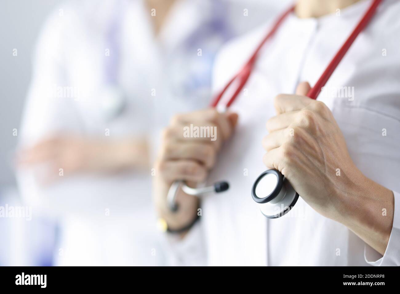 Doctor cardiologist holding red stethoscope in office of clinic closeup ...