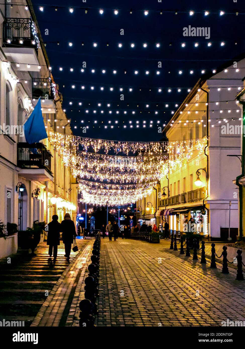 night town street with festive christmas illumination and walking ...