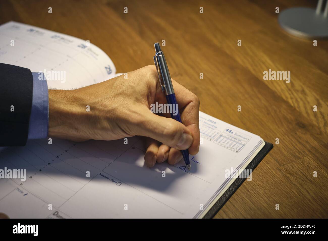 A closeup of a man's hand filling a daily planner - to-do list Stock ...