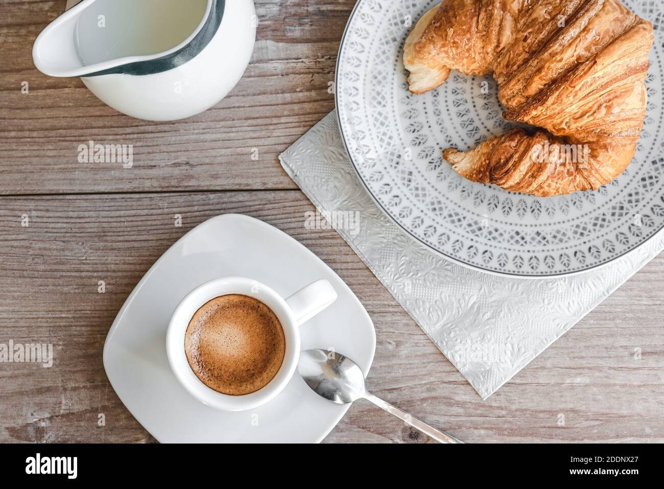horizontal top view of a table with a white cup of espresso coffee ...