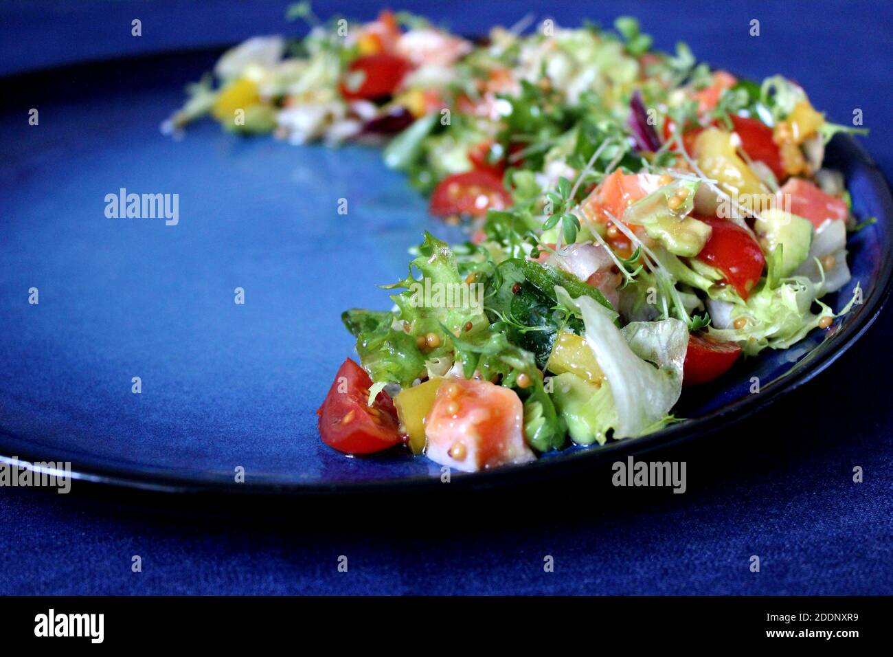 Fresh mixed vegetable salad on a blue background.Texture or background ...