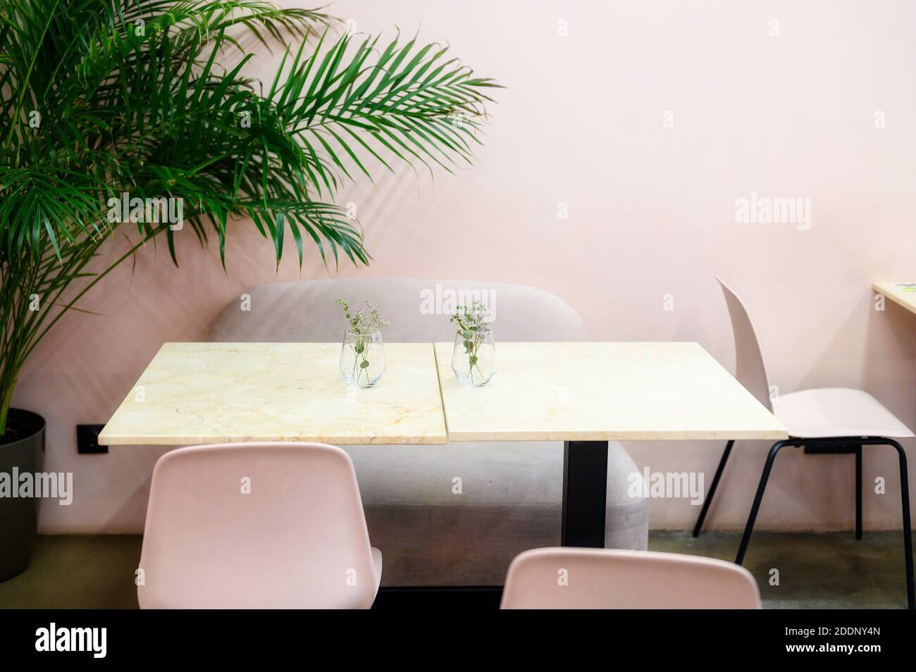 the interior of a cozy light cafe in natural pastel beige and pink ...