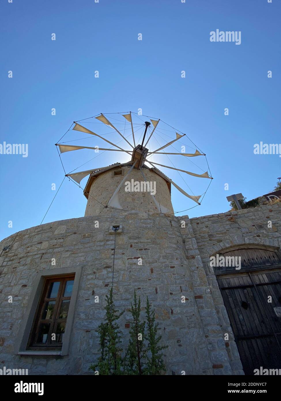 Ancient white stone wind mill building with wooden old heavy door ...