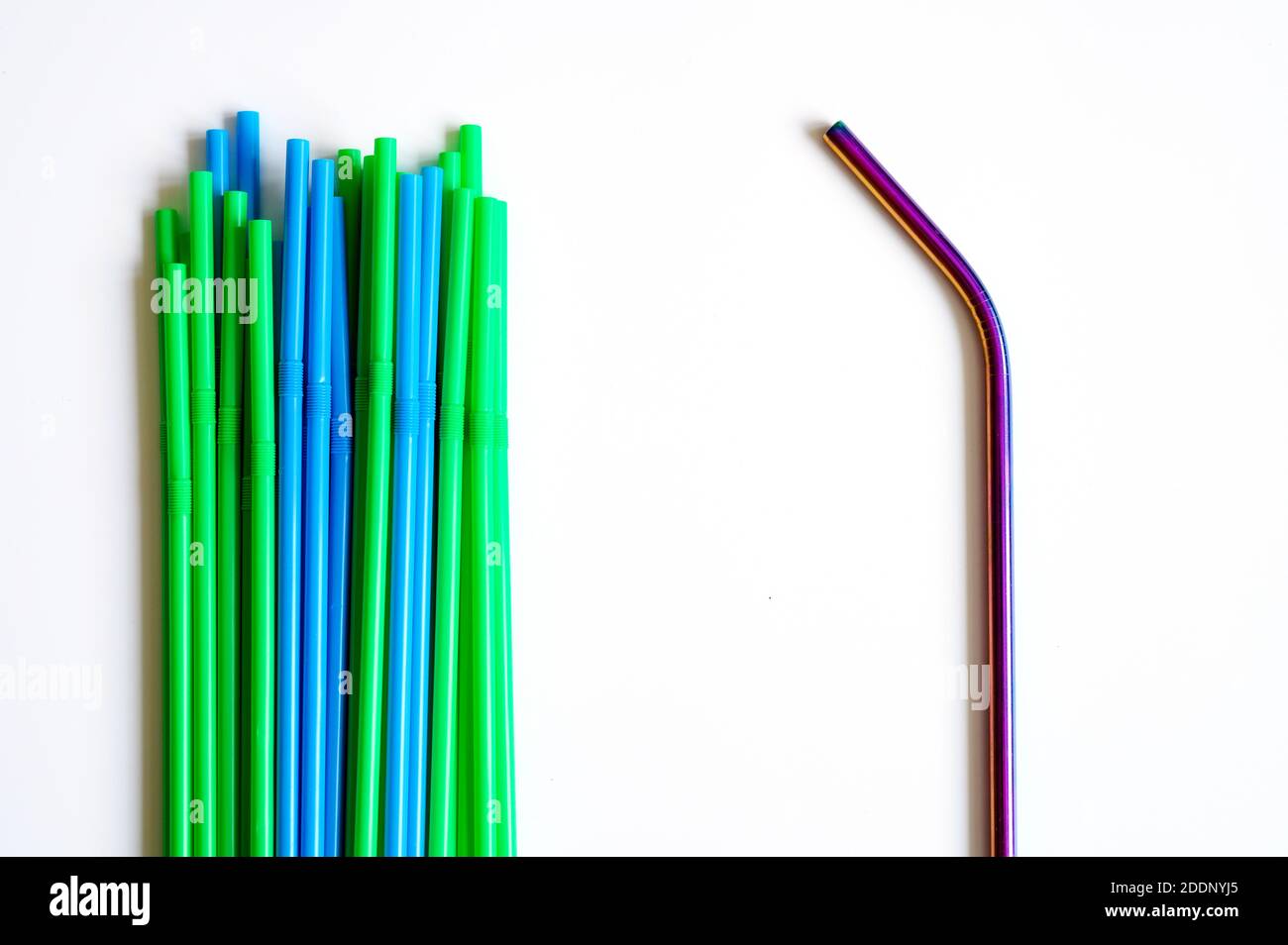a pile of disposable plastic drinking straws and one reusable stainless ...