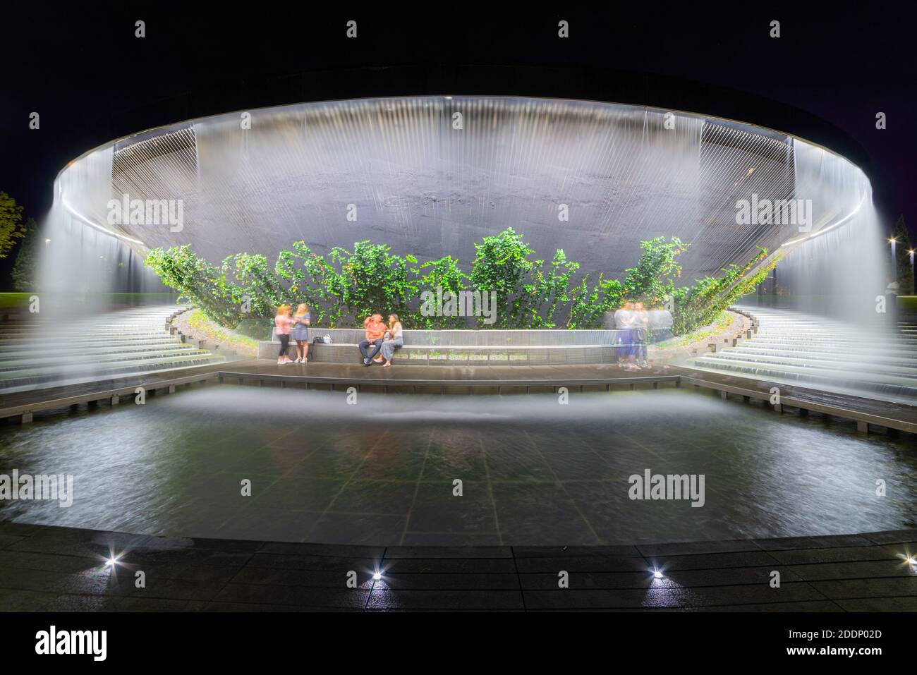 Waterfall flows in streams into granite bed of artificial river ...