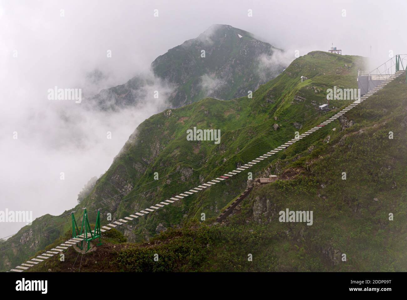 Hanging bridge over chasm in fog. Rope bridge between peaks in cloud ...