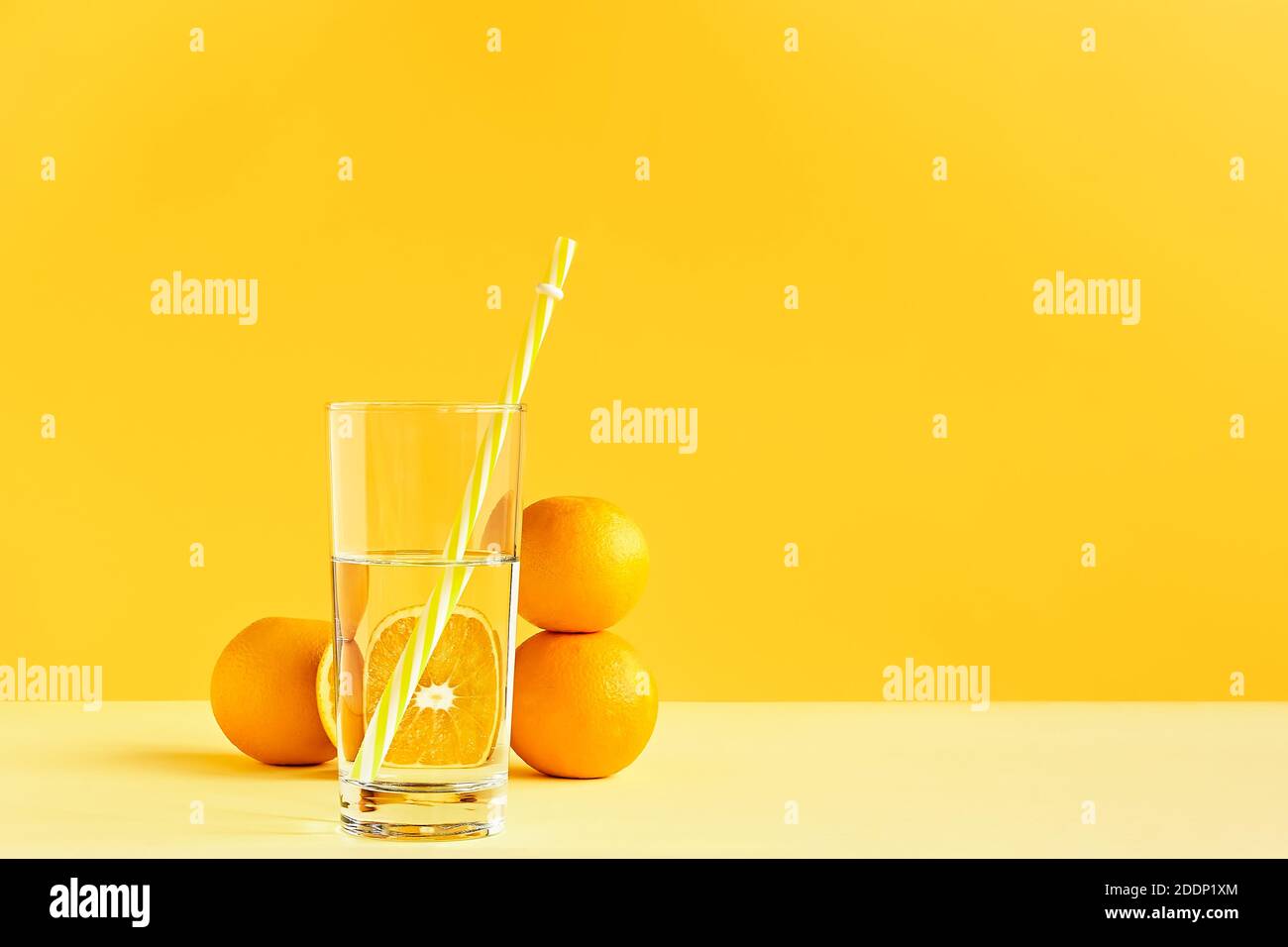 Citrus fruits distorted through water and glass on yellow background ...