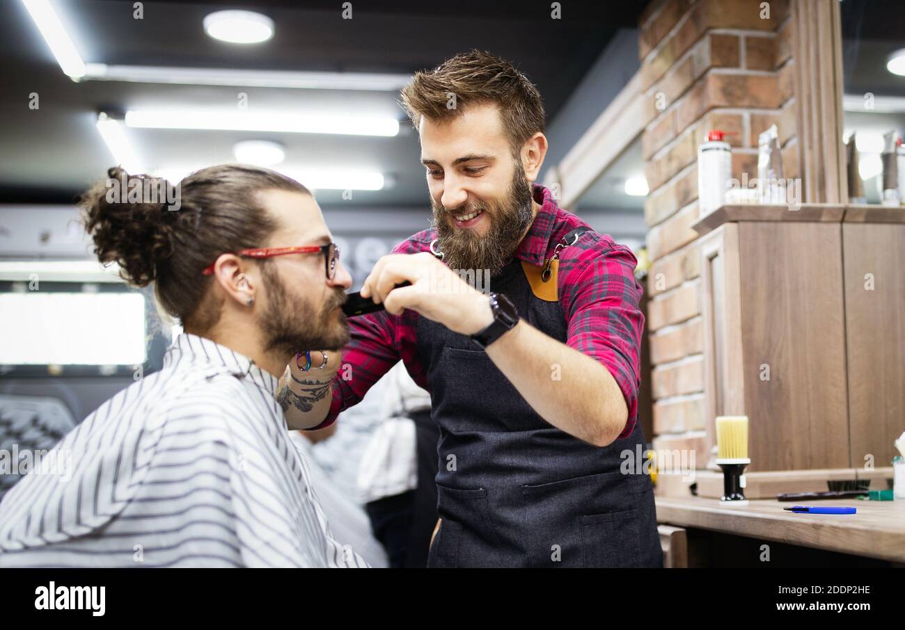Barber shaving a bearded man in a barber shop, close-up Stock Photo - Alamy