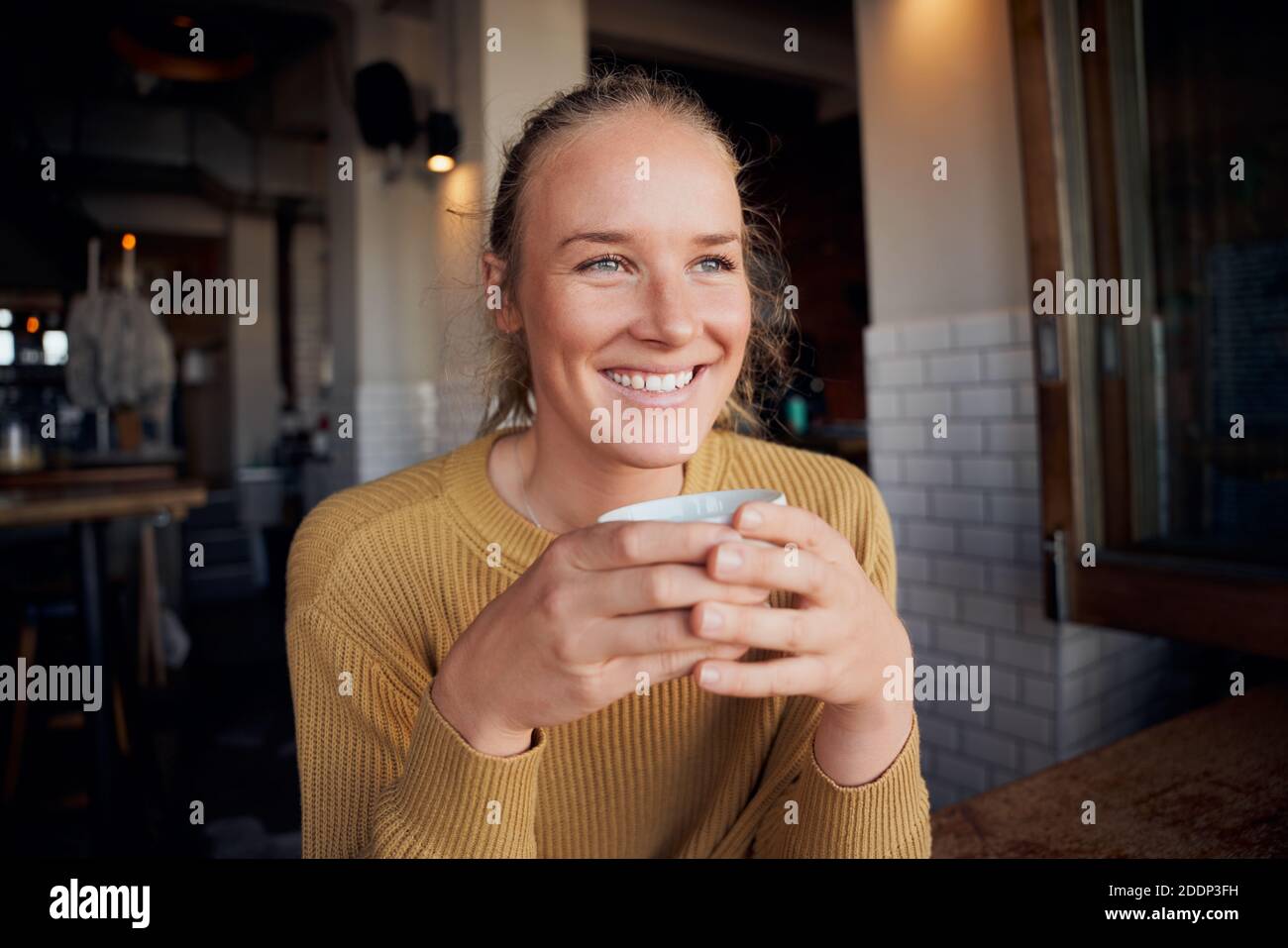 Smiling young woman holding coffee cup hi-res stock photography and ...