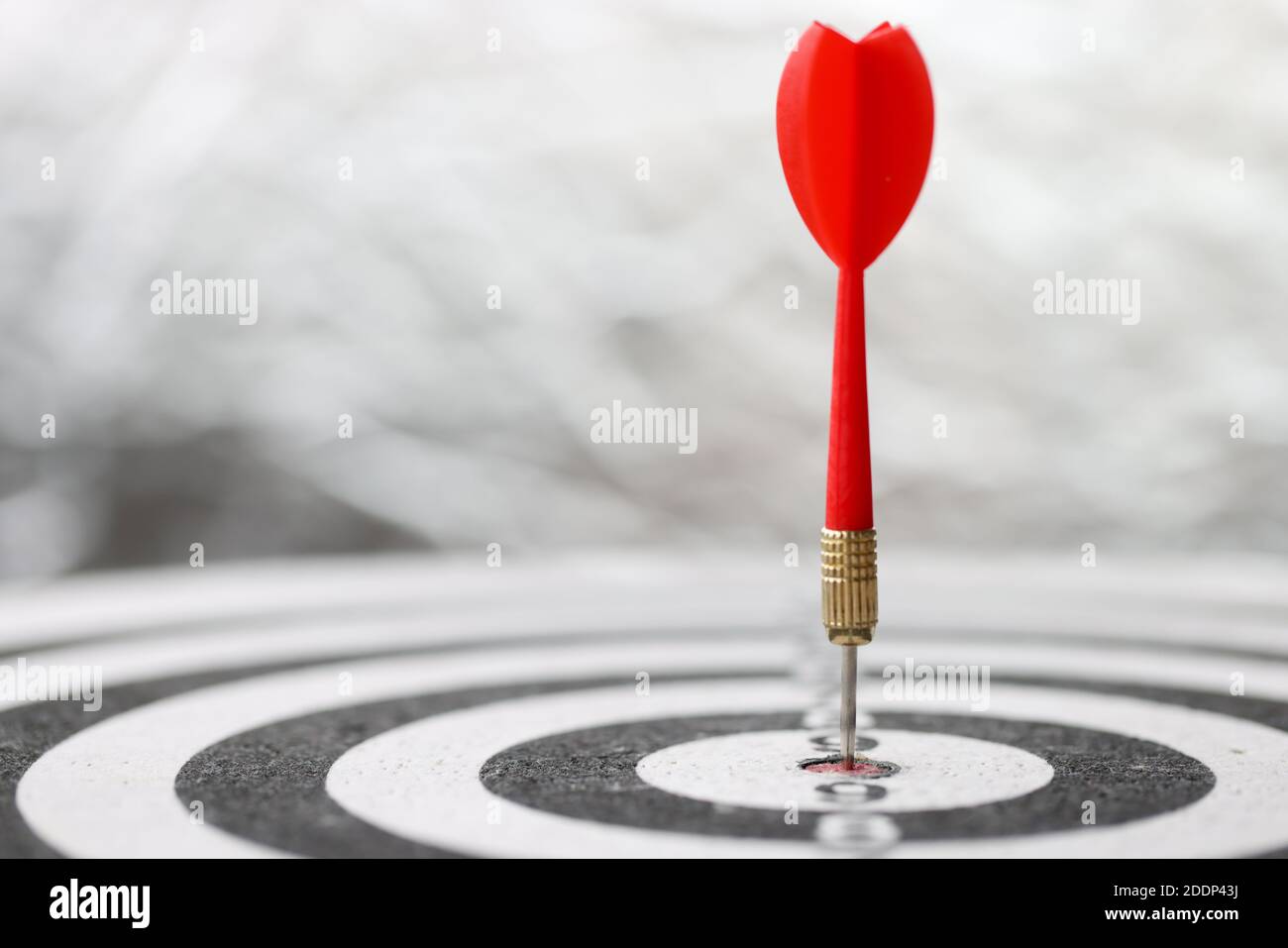 Dart sticks out in center of black white dart Stock Photo - Alamy