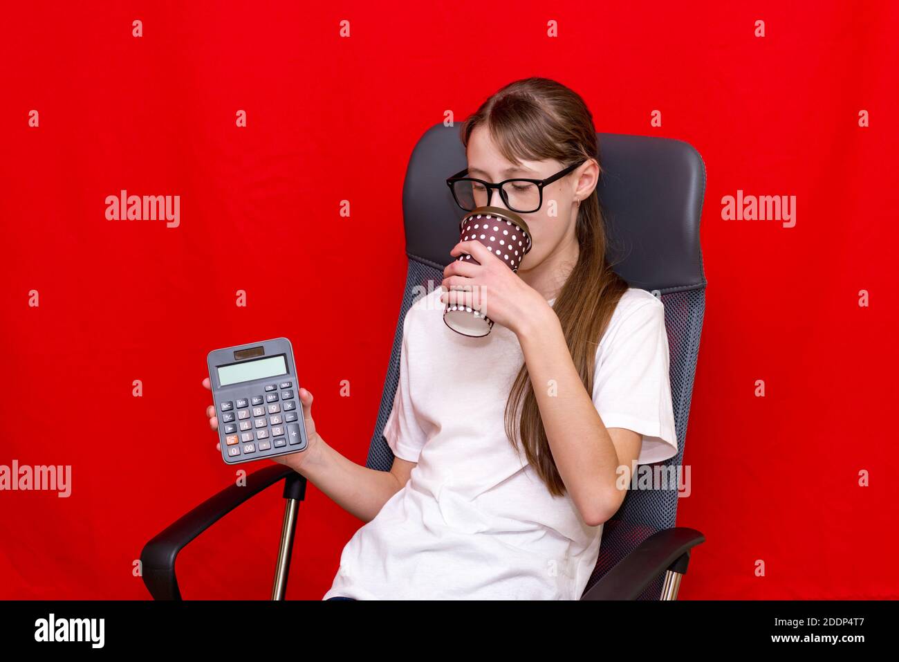 Young surprised caucasian girl counting calculator drinks coffee ...